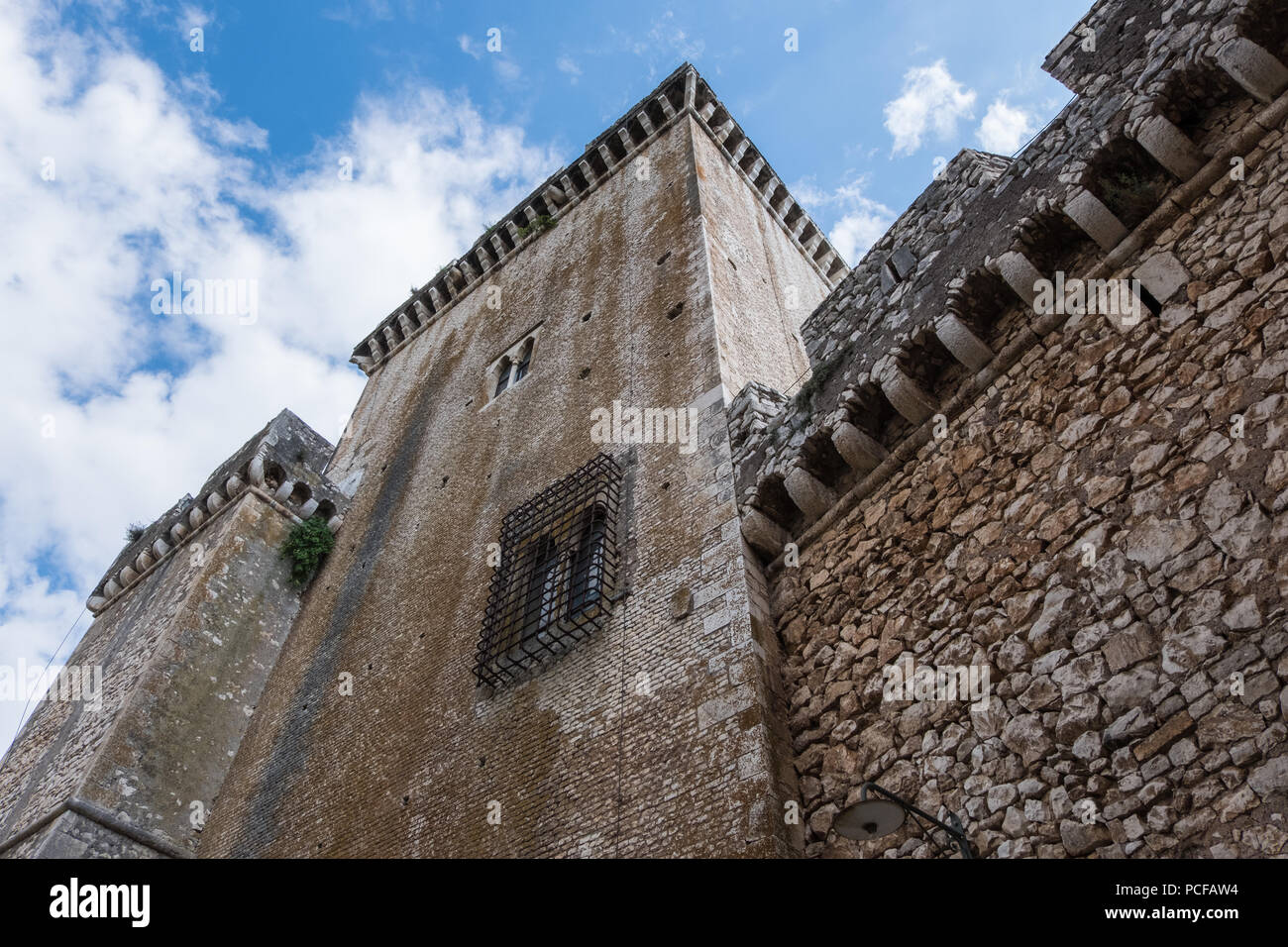 Tower window of an ancient stone castle with blue sky and clouds ...