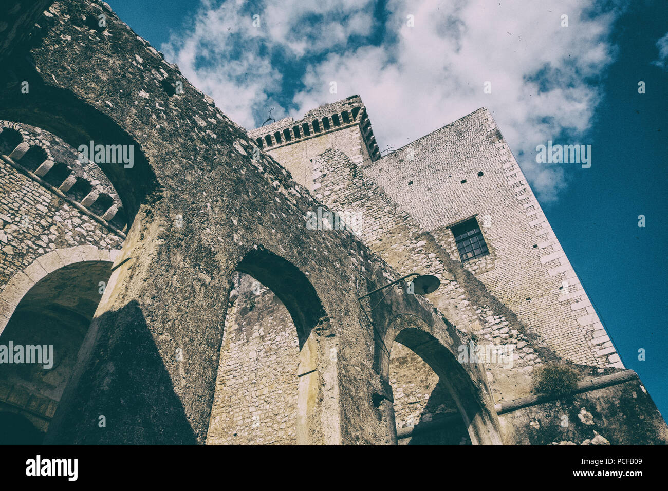 Arches of a stone medieval castle with blue sky and clouds background ...