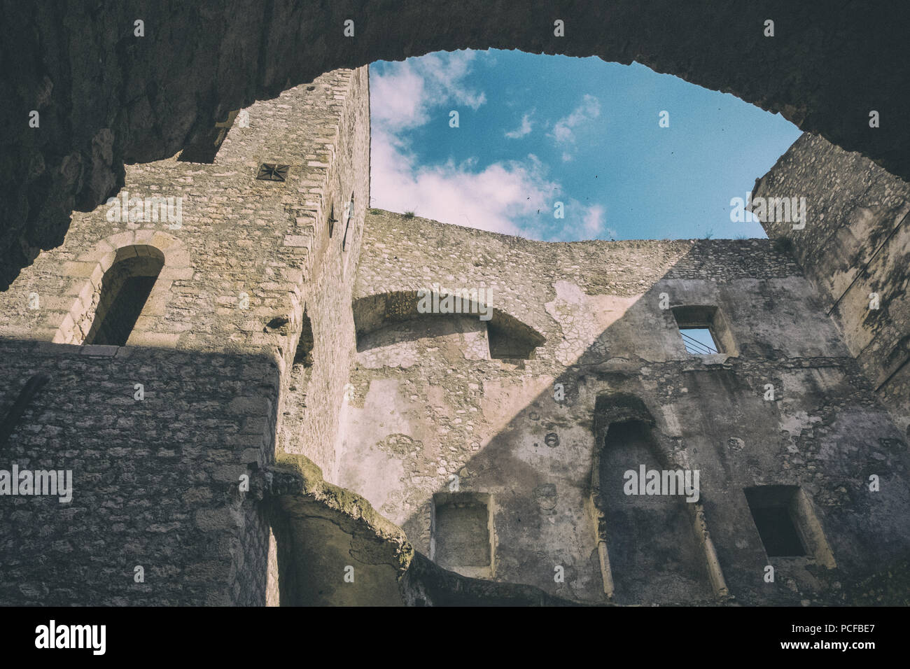 Low angle view of an ancient stone wall castle with blue sky background ...