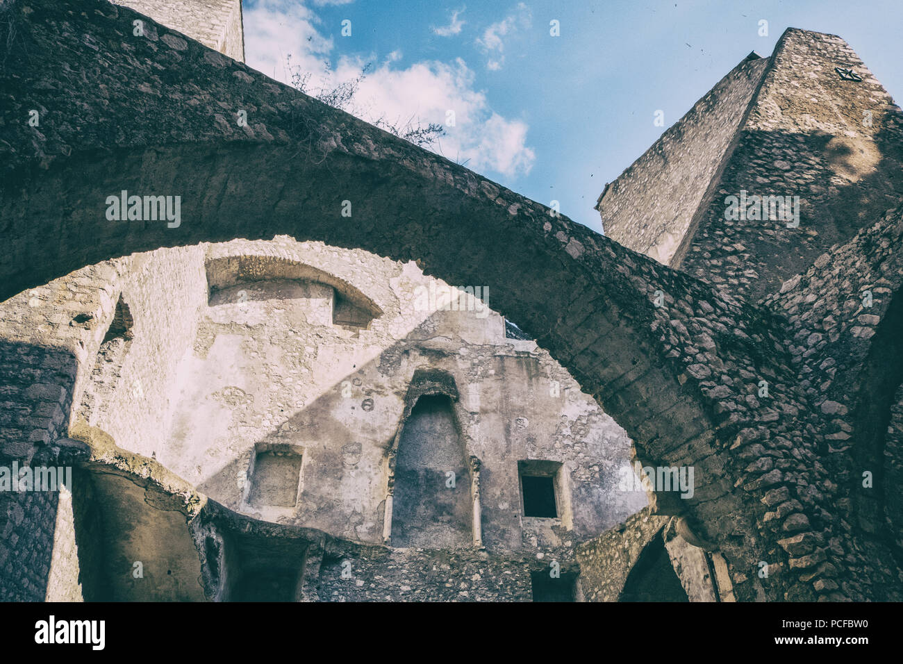 Low angle view of arches of a medieval stone castle with blue sky ...