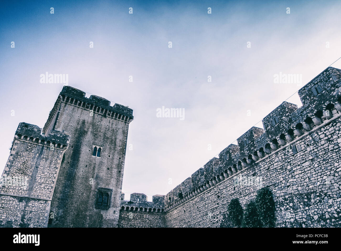 Walls and tower of medieval castle with clouds and blue sky background ...