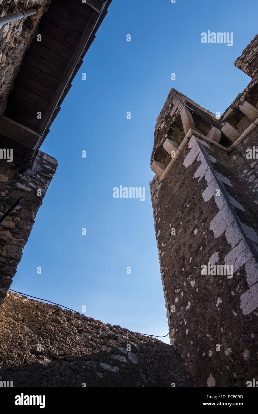 Low angle photo of worn stone walls of a castle with blue sky ...