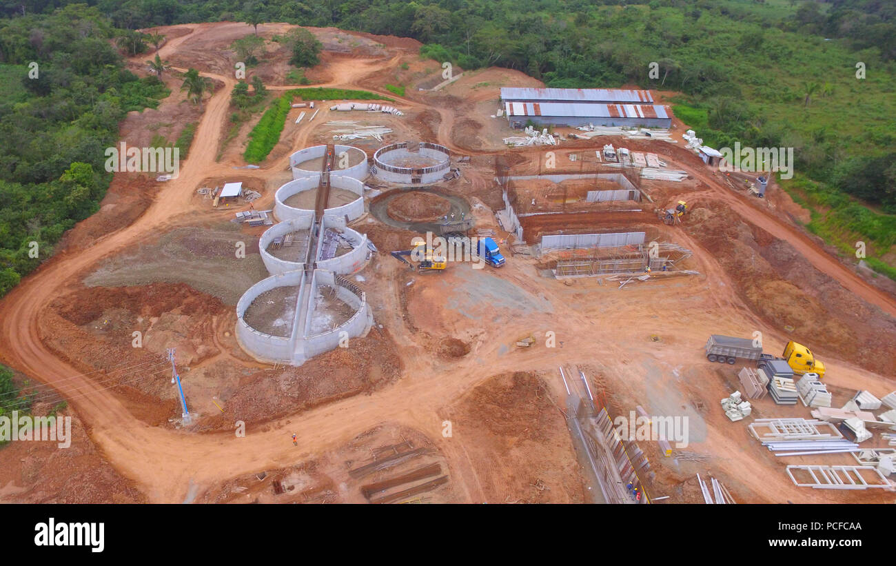 Aerial view of a construction site with trailers unloading raw ...