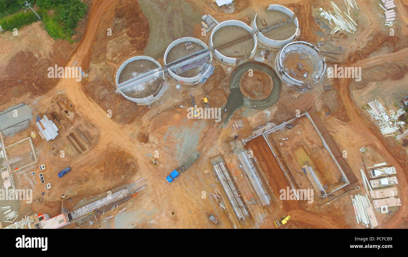 Aerial view of a construction site with trailers unloading raw ...