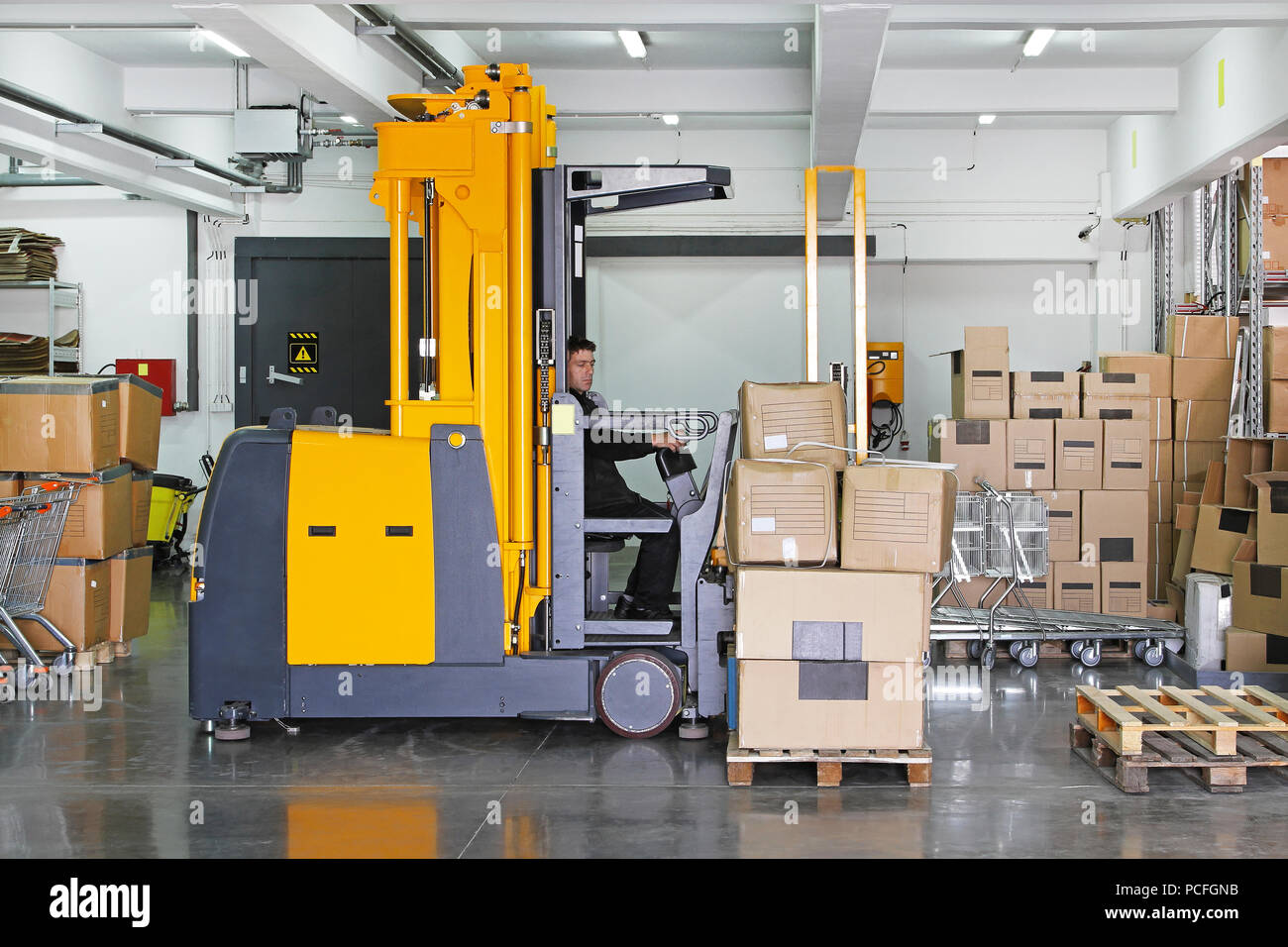 Electric forklift stacker in warehouse with boxes Stock Photo - Alamy