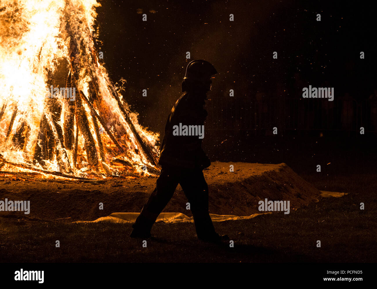 Geneva, Switzerland. 1st Aug, 2018. A firefighter walks past a bonfire ...