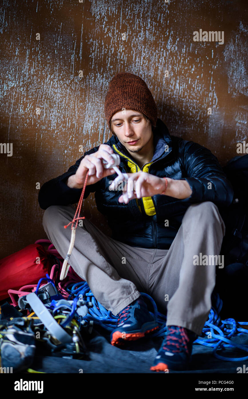 Handsome rock climber preparing for training. Shallow depth of field ...