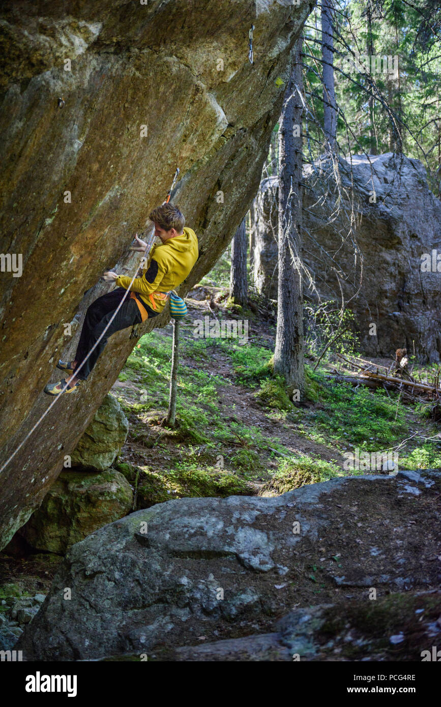 Rock climber ascending a challenging cliff. Extreme sport climbing ...