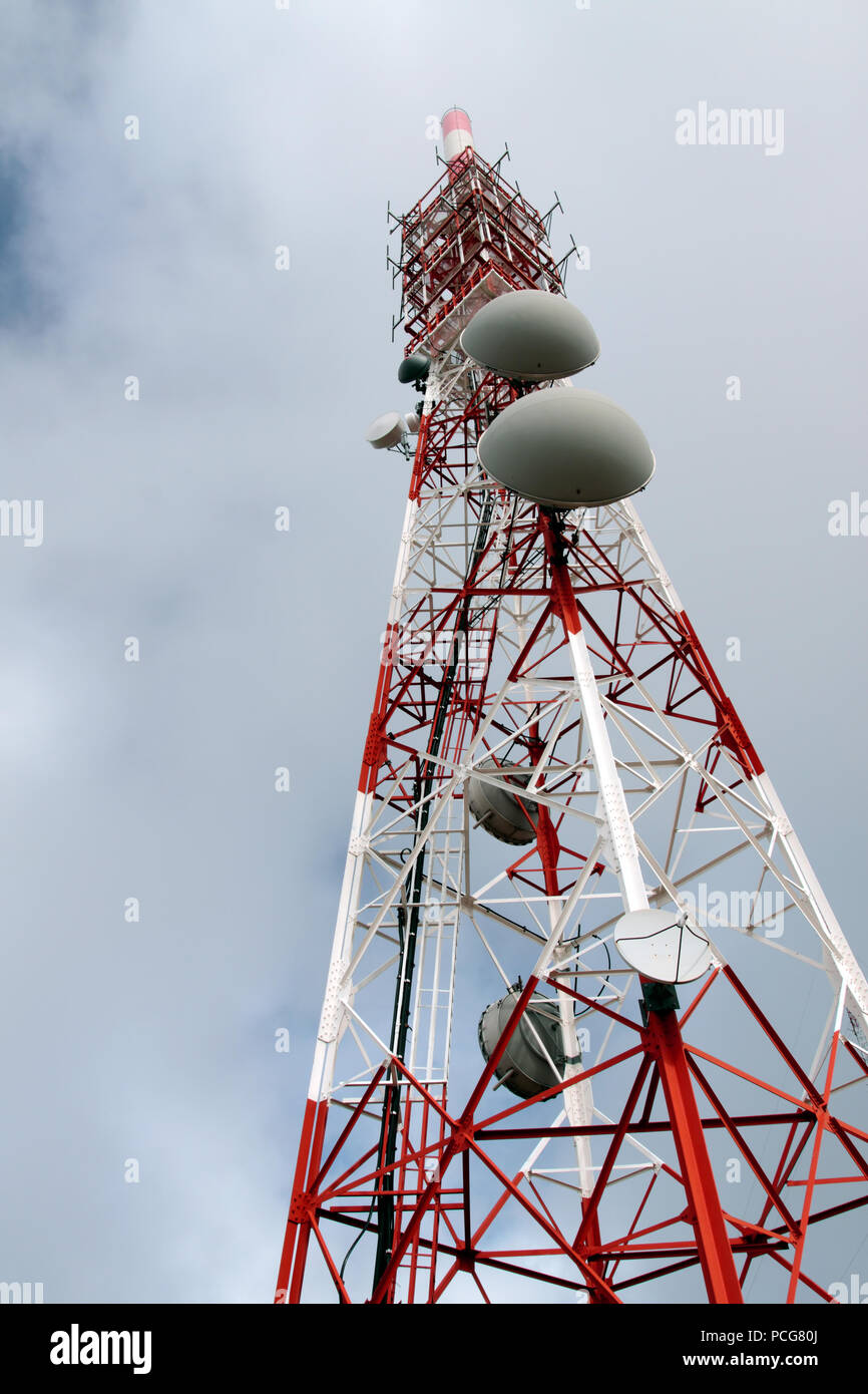 Red and white tower of communications with their antennas in a misty ...