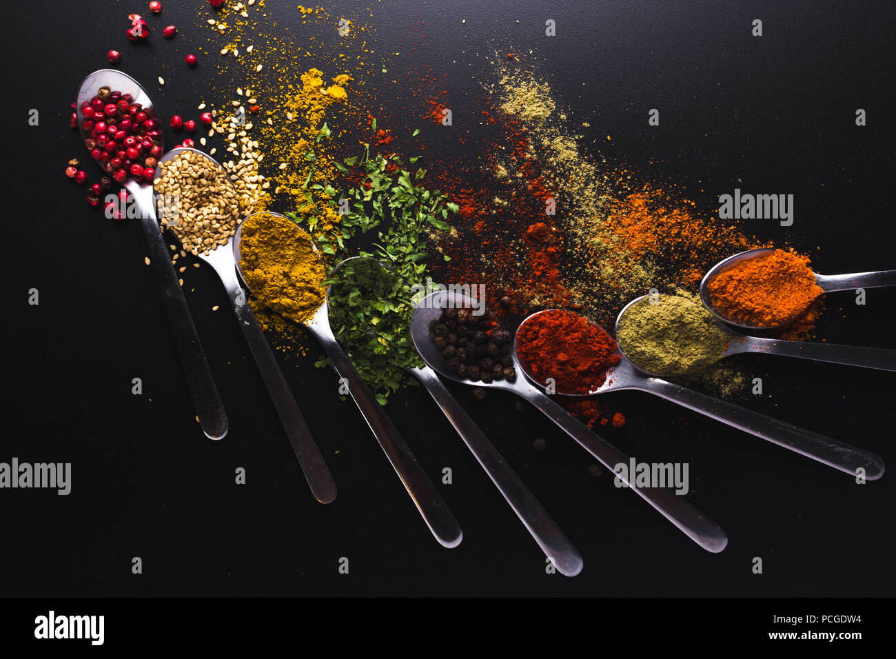 Composition of small spoons full of spices and condiments for cooking ...