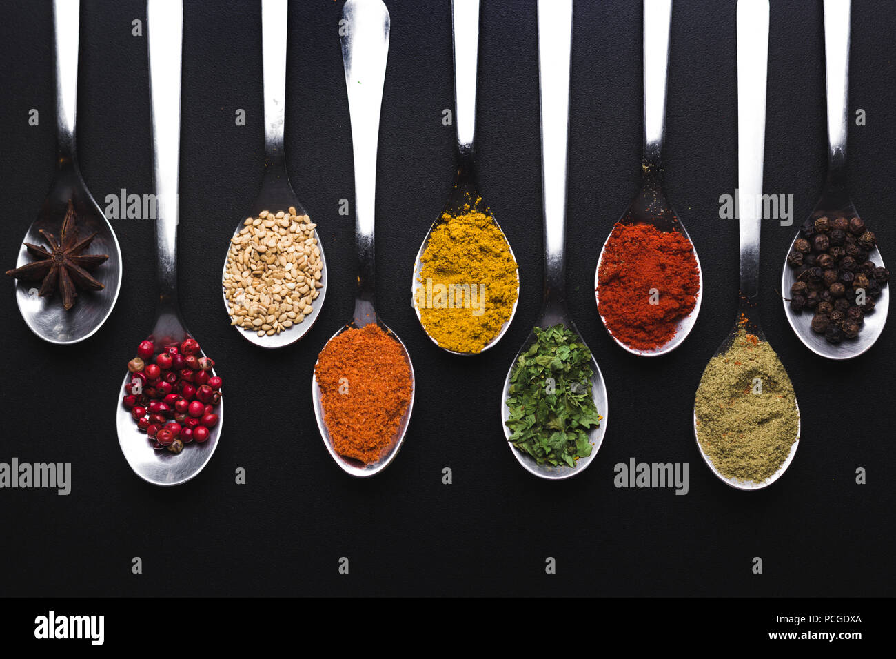 Spices and condiments for cooking on a black background Stock Photo - Alamy