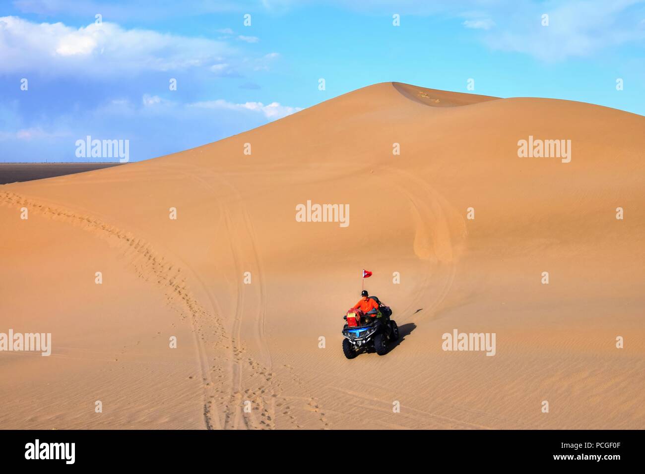Go-kart going through the sand dunes on the desert with blue sky and ...