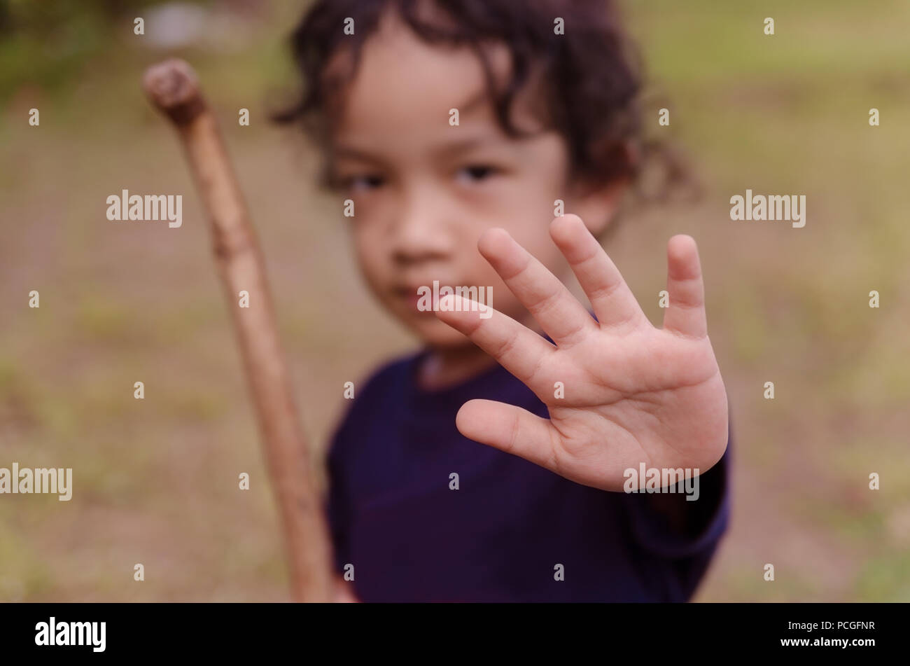 A boy showing an open hand signal that means stop or wait isolated on a ...
