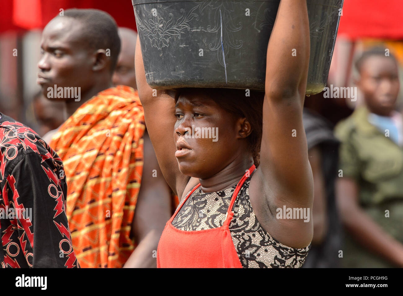 KUMASI, GHANA - JAN 16, 2017: Unidentified Ghanaian woman with a bucket ...