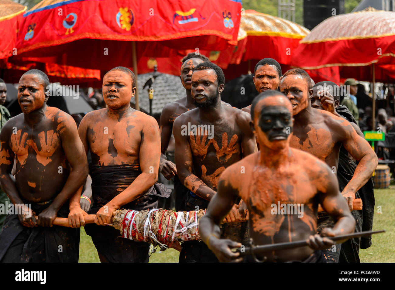 KUMASI, GHANA - JAN 16, 2017: Unidentified Ghanaian men in orange mud ...