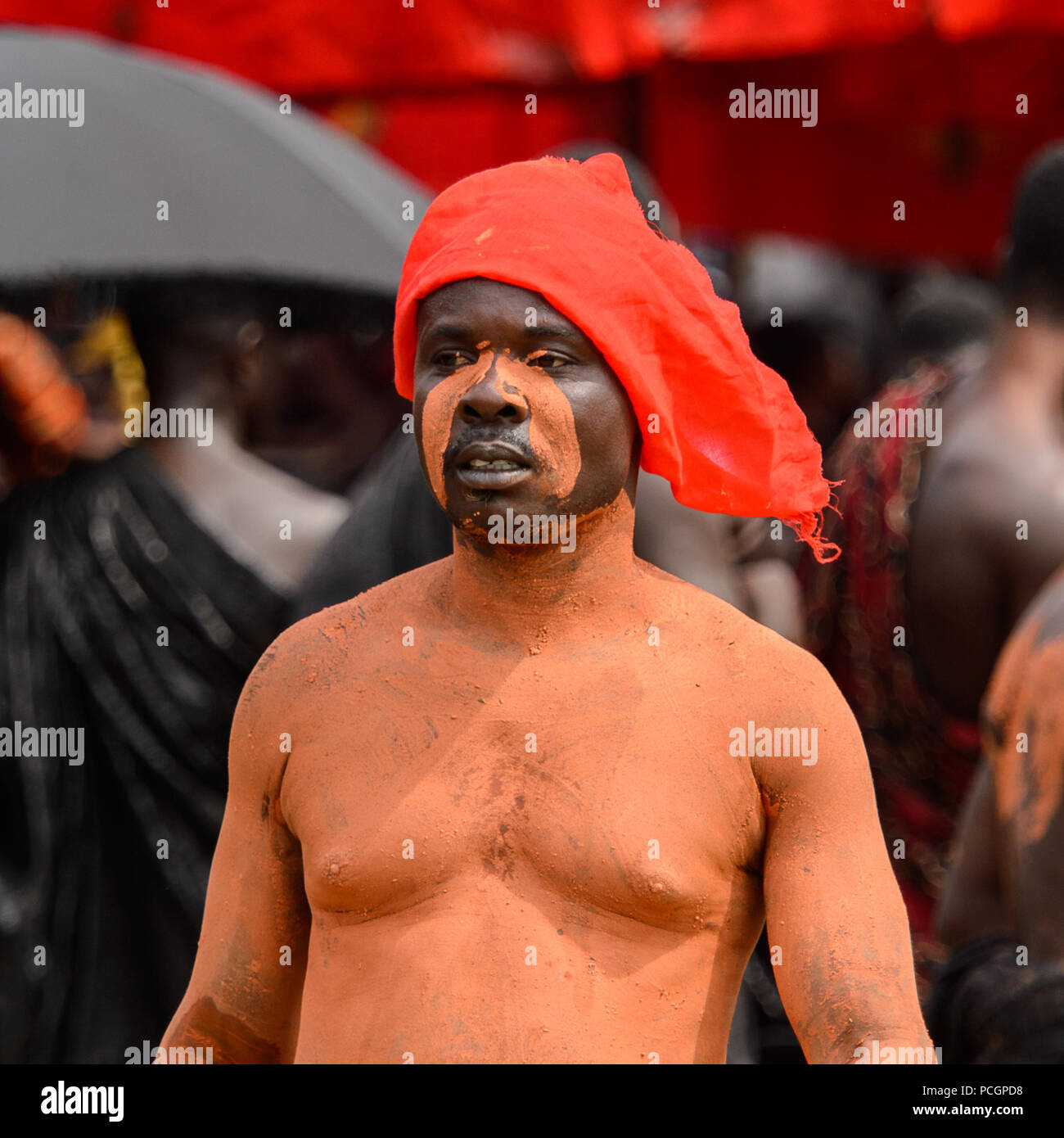 KUMASI, GHANA - JAN 16, 2017: Unidentified Ghanaian man in orange mud ...
