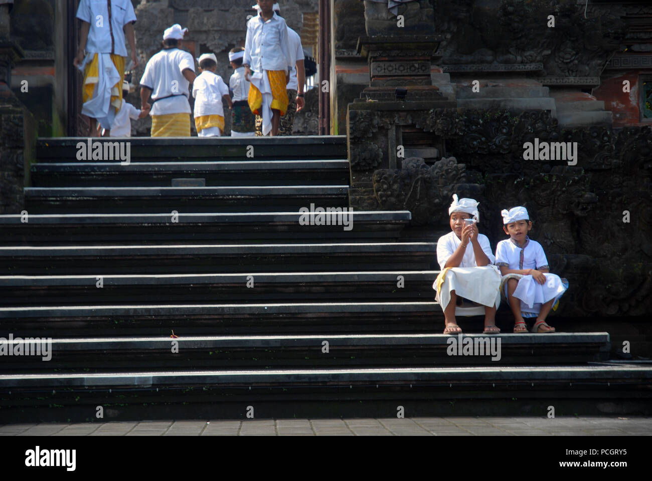 A Hindu temple procession, men and boys on the temple steps, Ubud, Bali ...
