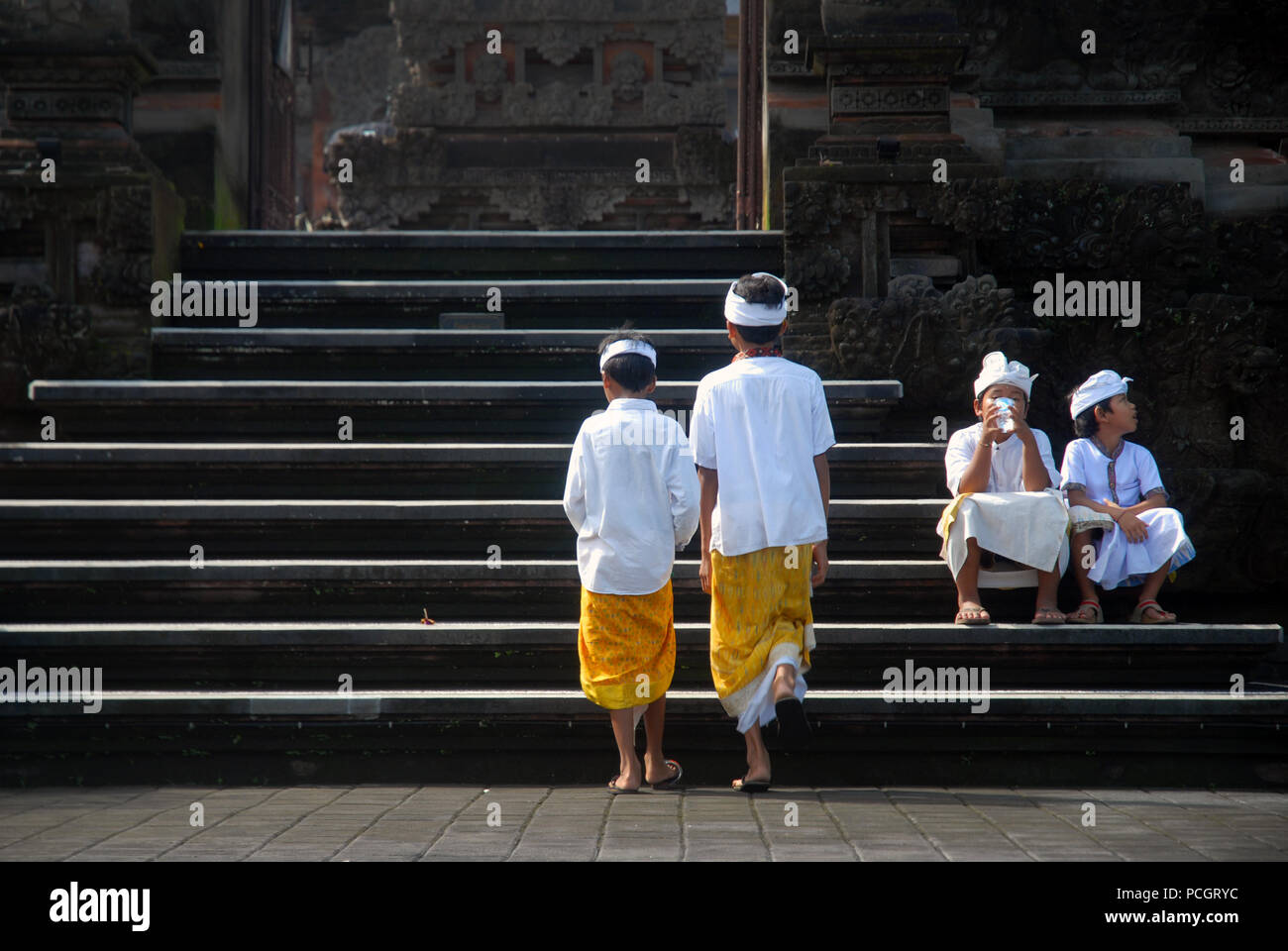 A Hindu temple procession, men and boys on the temple steps, Ubud, Bali ...