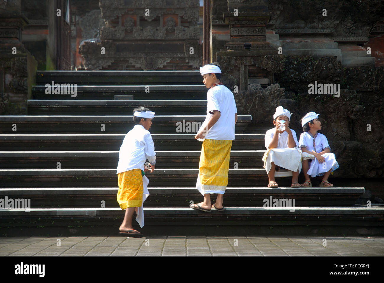 A Hindu temple procession, men and boys on the temple steps, Ubud, Bali ...