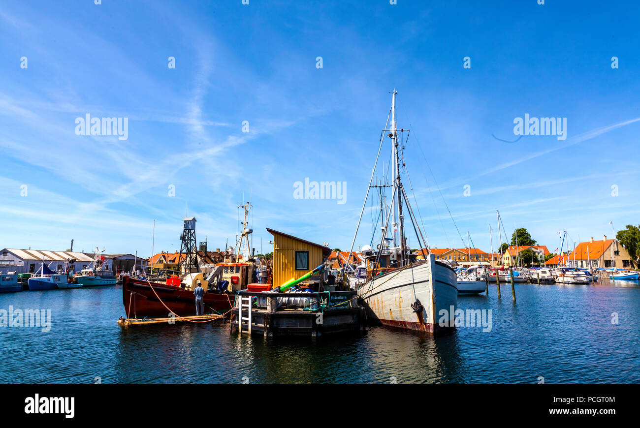 Fisherman working on his boat moored in the harbour at Dragør fishing ...