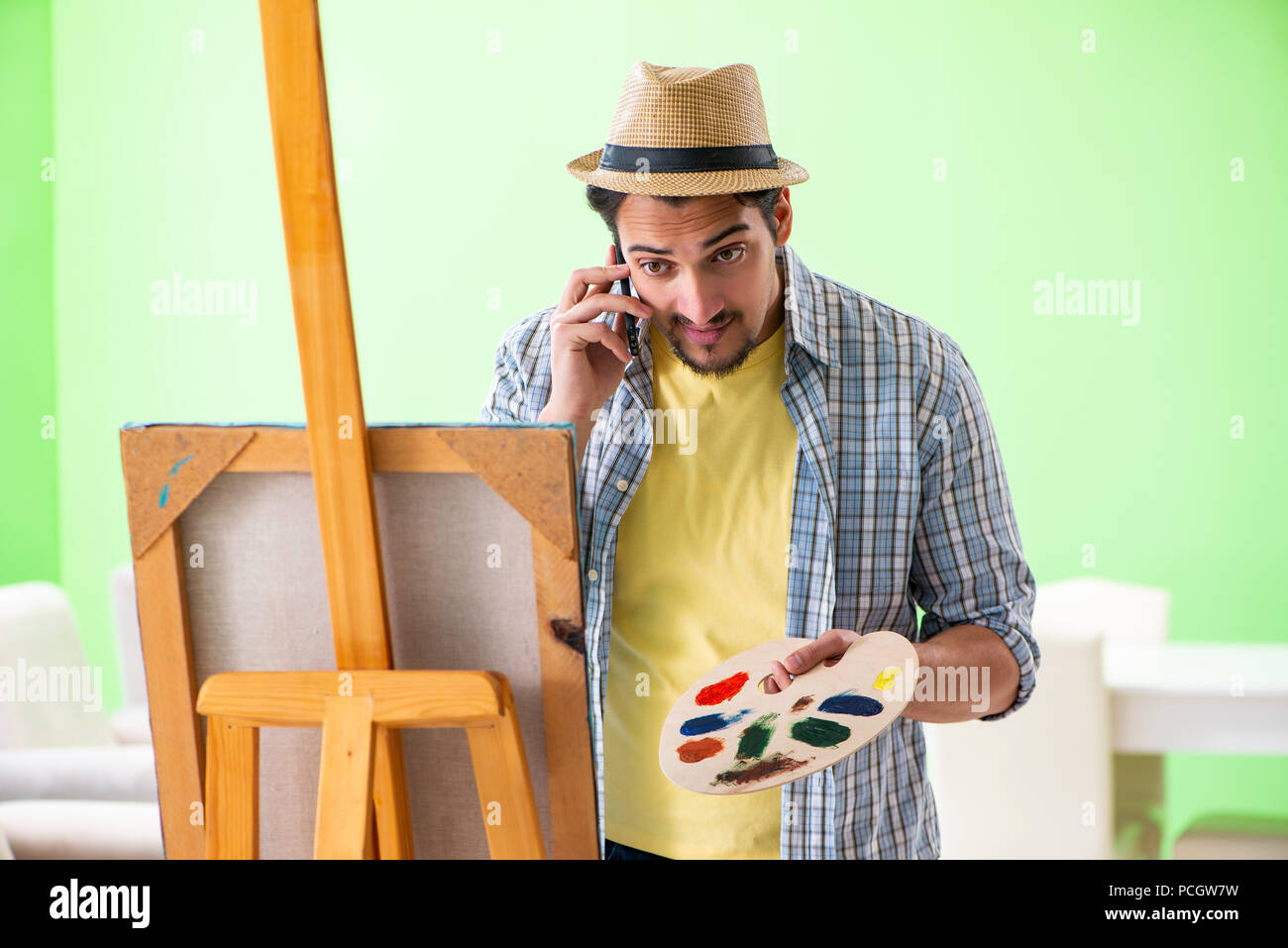 Young male artist working on new painting in his studio Stock Photo - Alamy