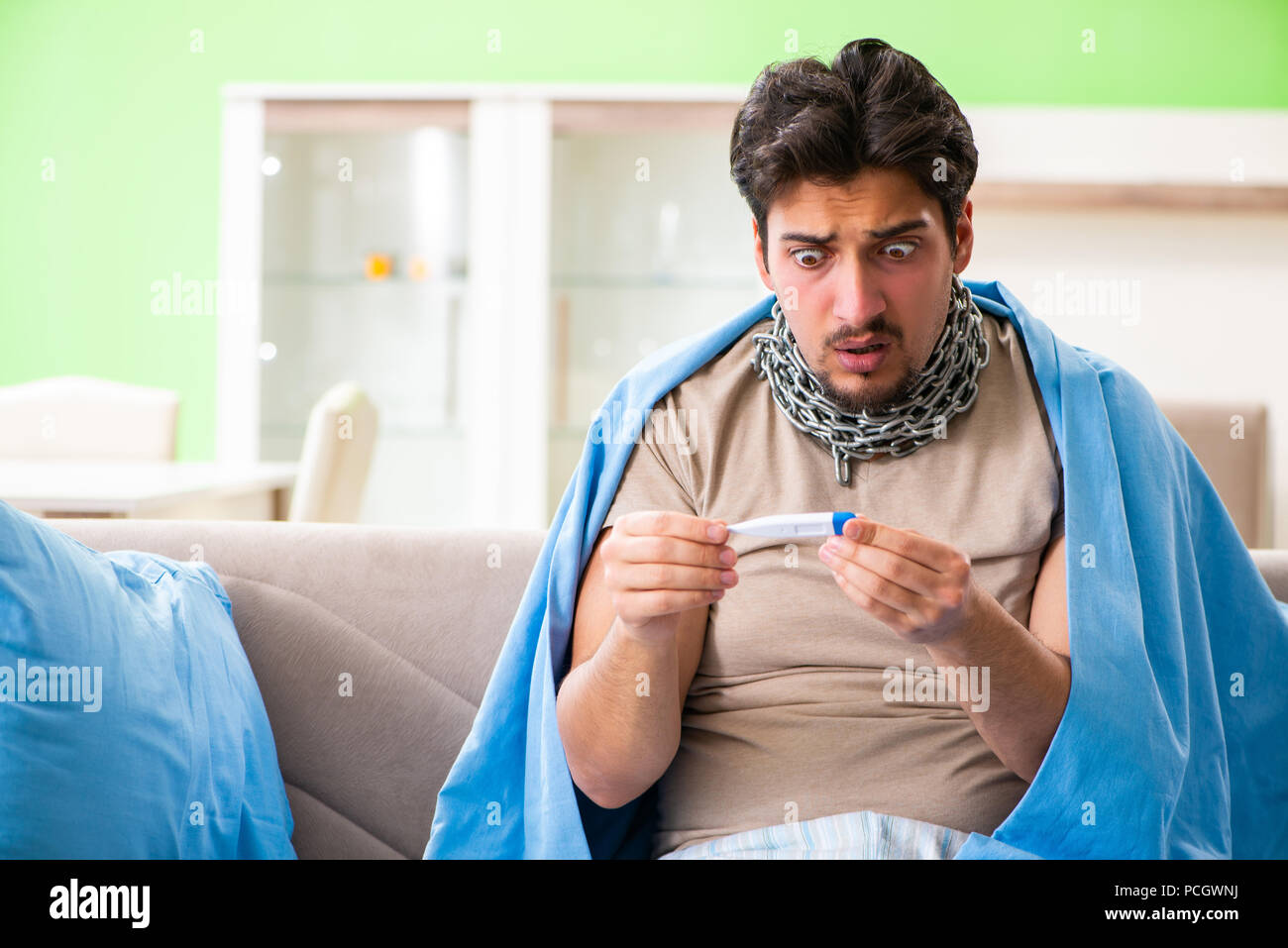 Sick young man suffering from flu at home Stock Photo - Alamy