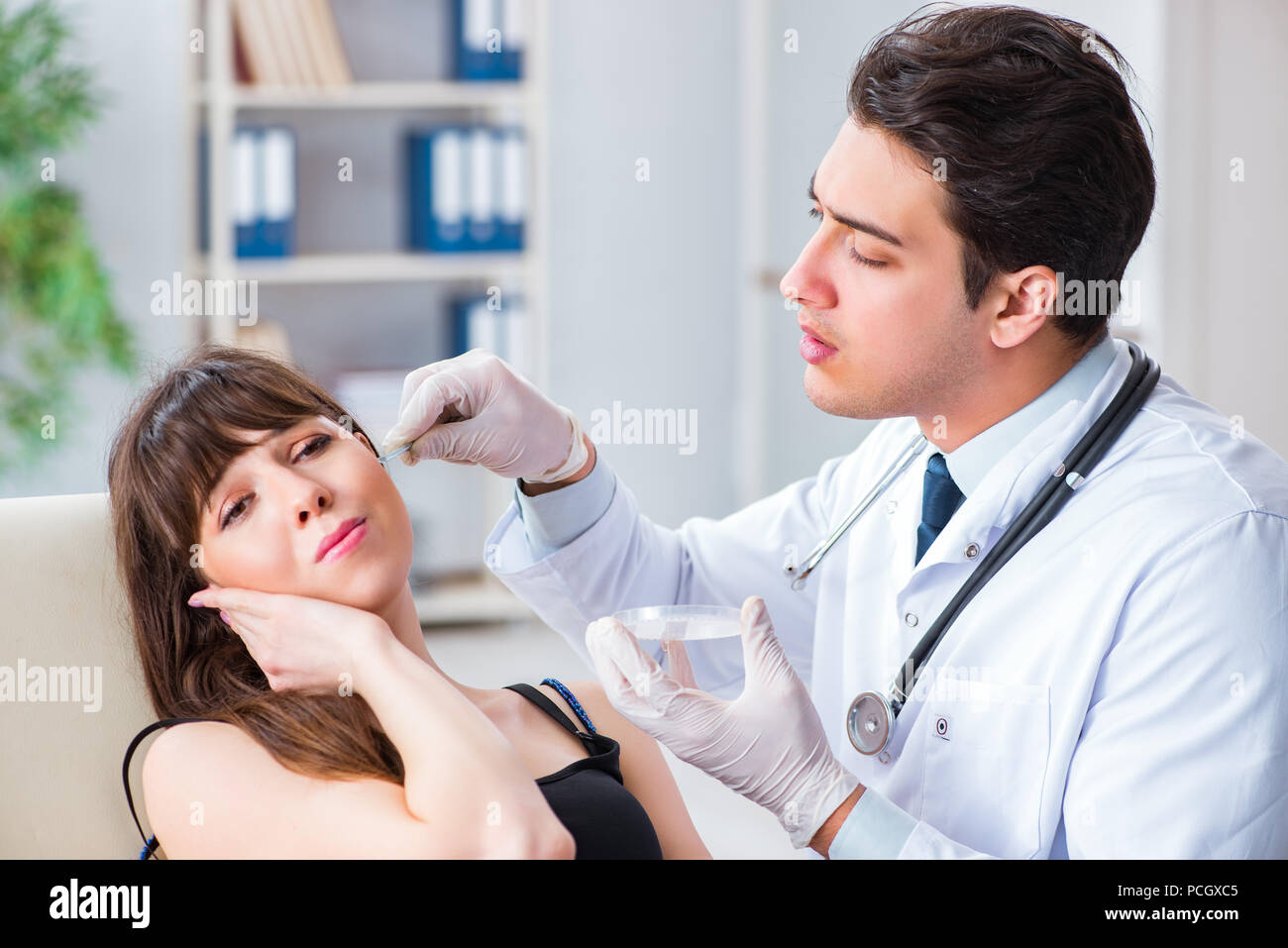Doctor checking patients ear during medical examination Stock Photo - Alamy