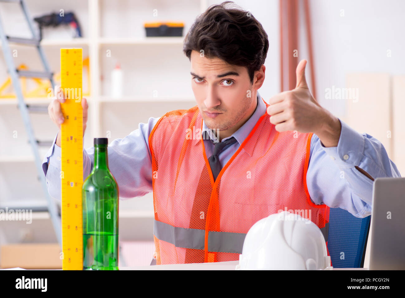 Drunk engineer working in the workshop Stock Photo - Alamy