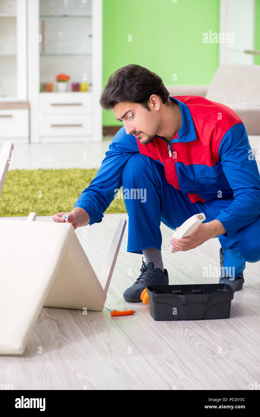 Repair contractor repairing broken chair at home Stock Photo - Alamy