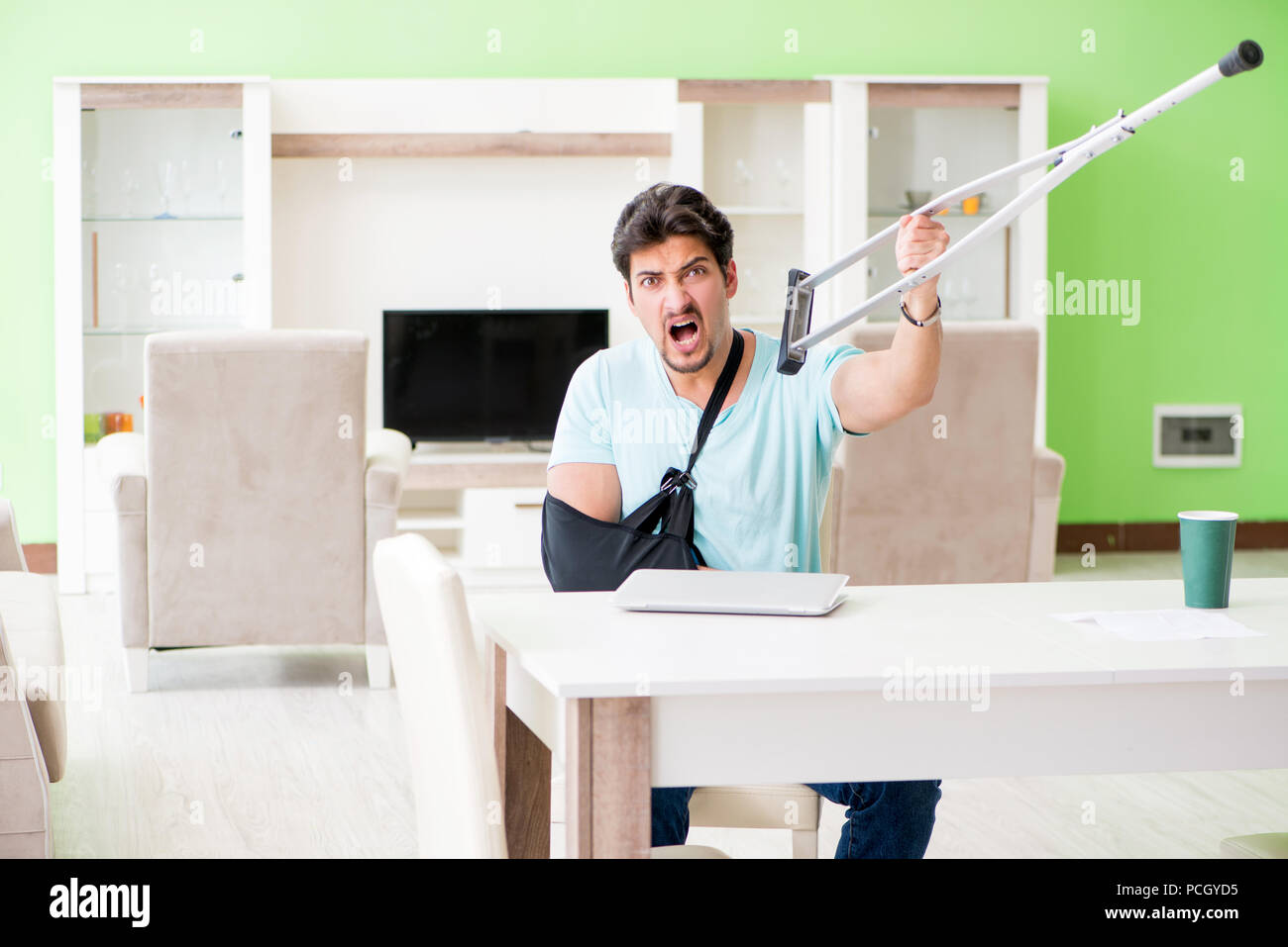 Injured man with crutches sitting at home Stock Photo - Alamy