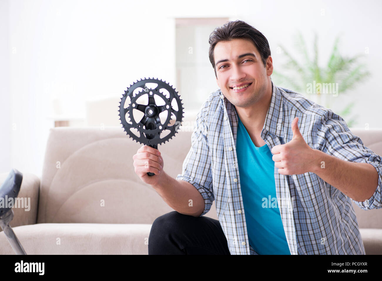 Young man repairing bicycle at home Stock Photo - Alamy