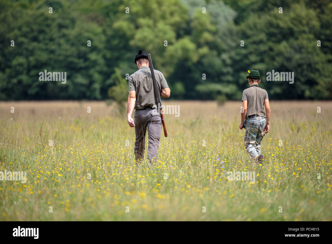 A ranger teaching his son about spotting the game in the wilderness ...