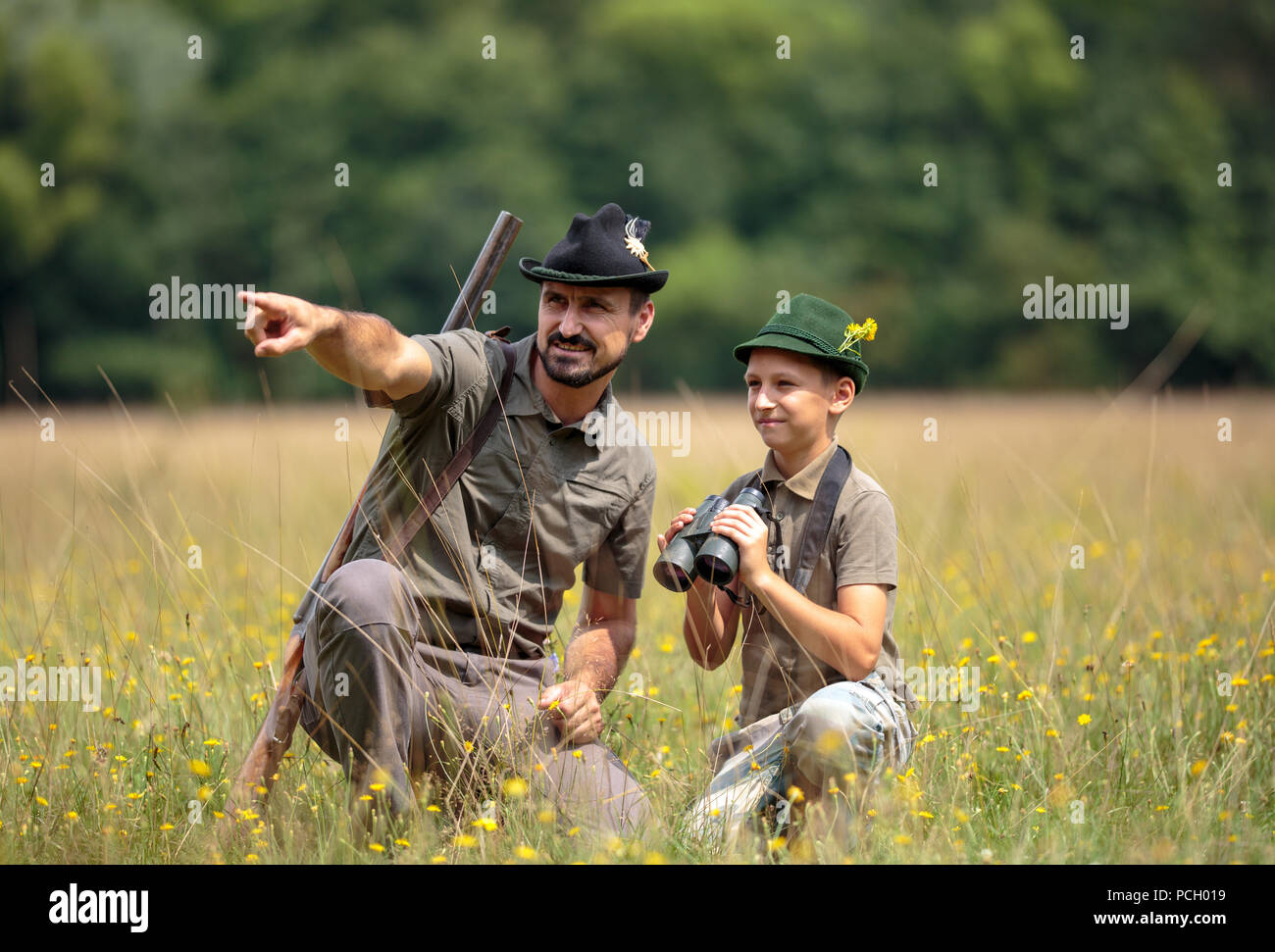 A ranger teaching his son about spotting the game in the wilderness ...