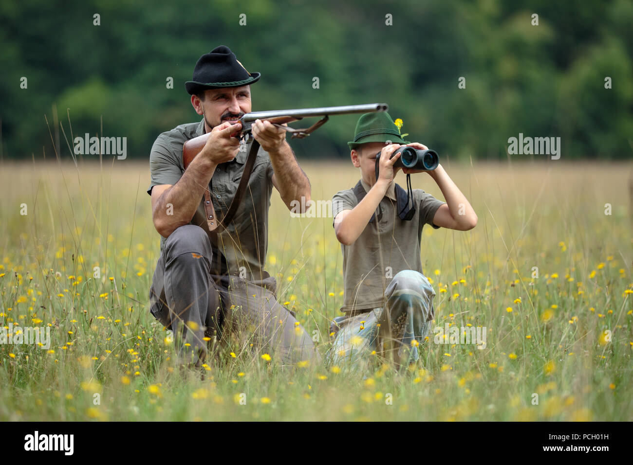 A ranger teaching his son about spotting the game in the wilderness ...