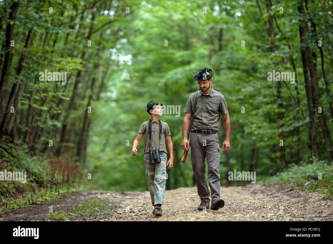 A ranger teaching his son about spotting the game in the wilderness ...