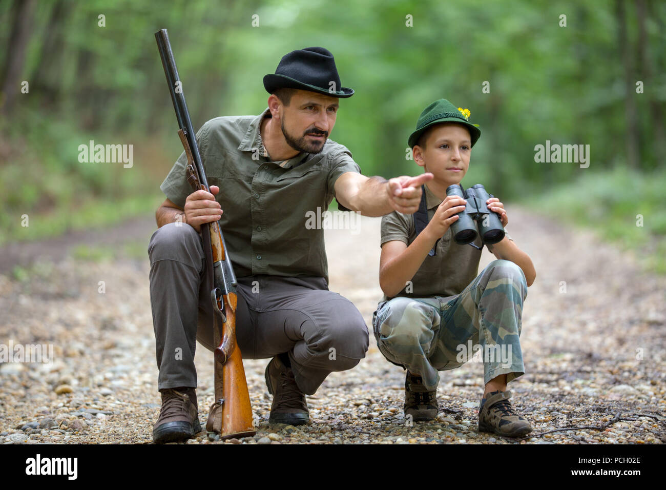 A ranger teaching his son about spotting the game in the wilderness ...
