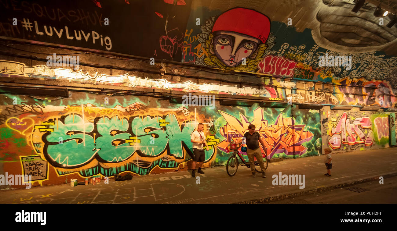 Man and child with bike talking to graffiti artist Stock Photo - Alamy