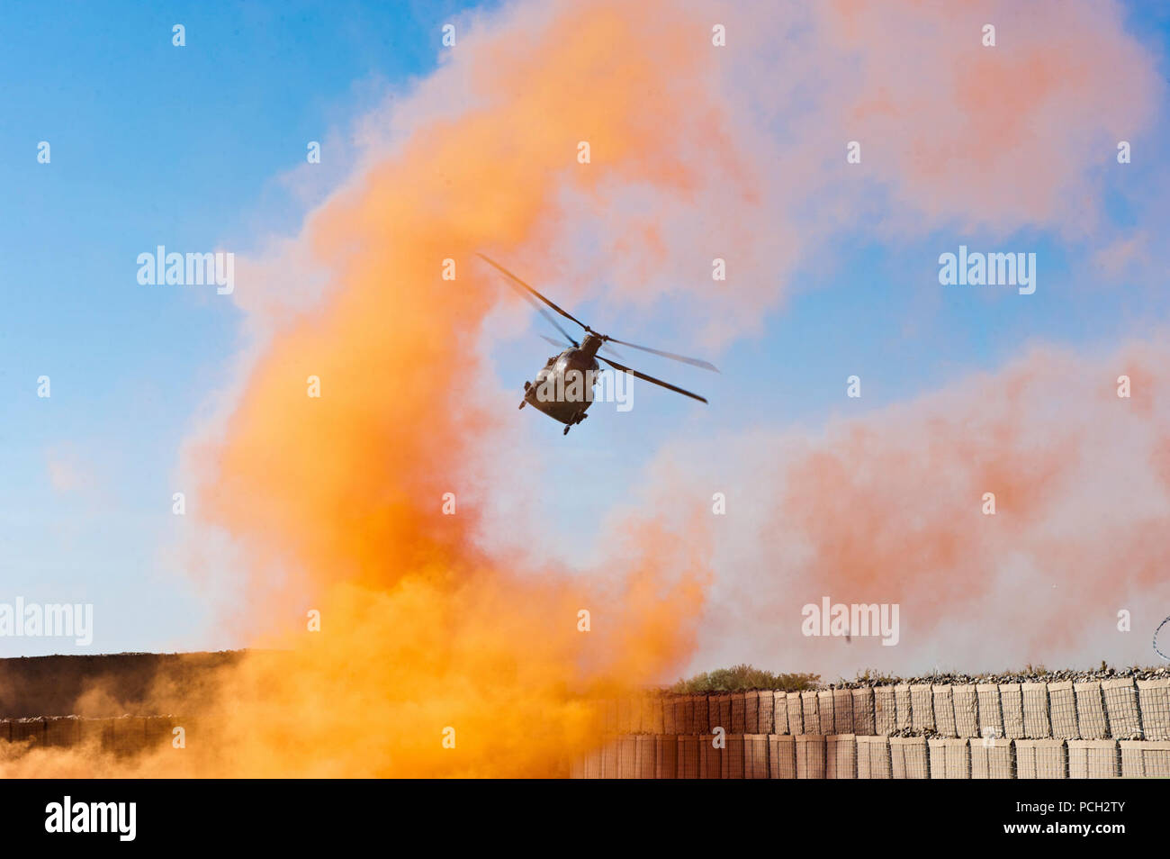 A Royal Air Force HC2 Chinook helicopter flies through smoke as it ...