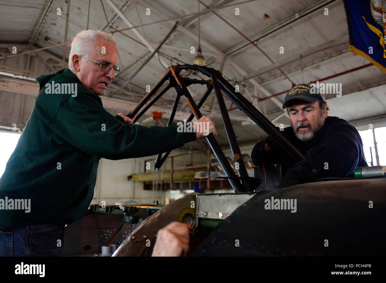 Garnett “Lee” West (right) and Joseph Walther position a restored ...