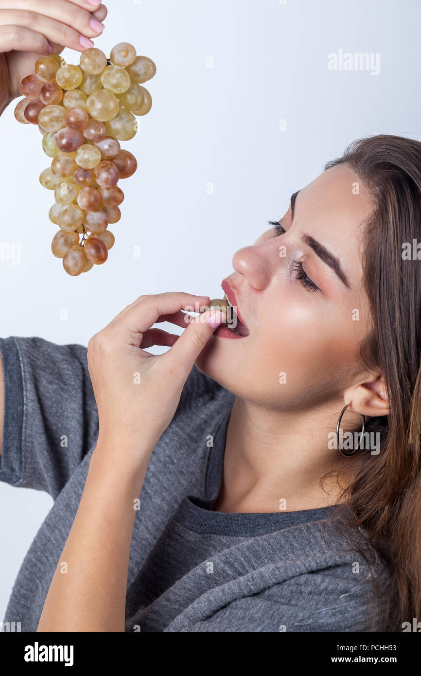 beautiful young lady holding grape on white background Stock Photo - Alamy