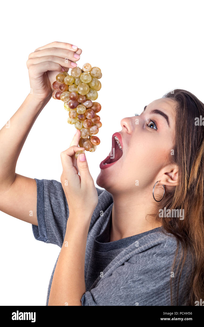 beautiful young lady eating grape on white background Stock Photo - Alamy