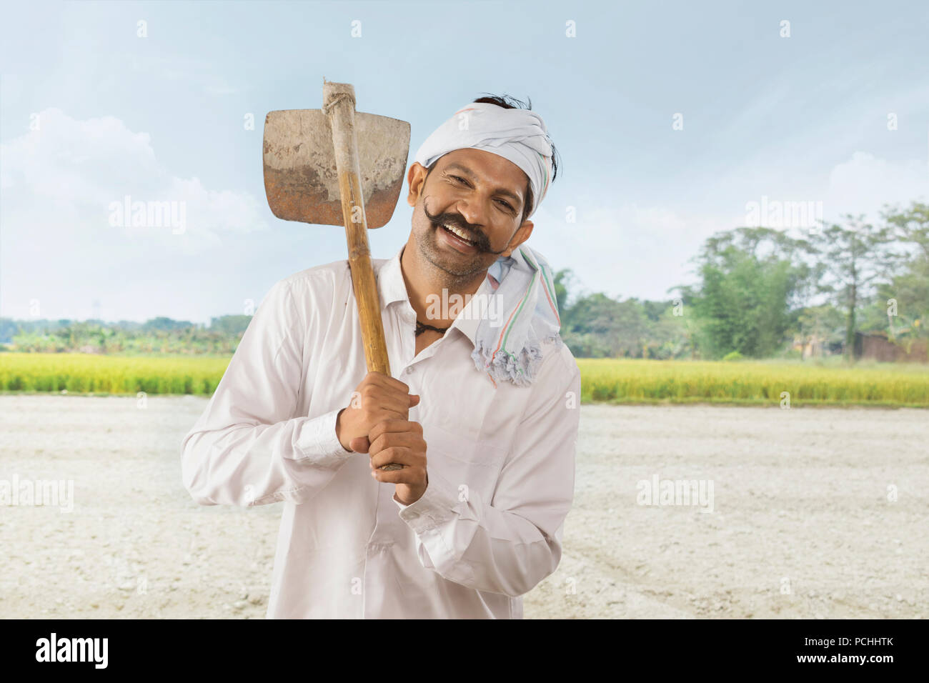Indian farmer carrying hoe on his shoulder standing in field Stock ...