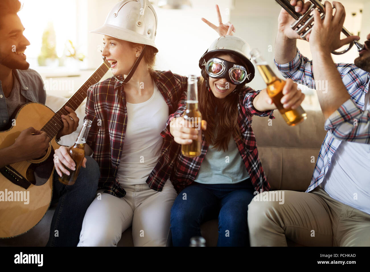 Cheerful friends having party together and playing instruments Stock ...