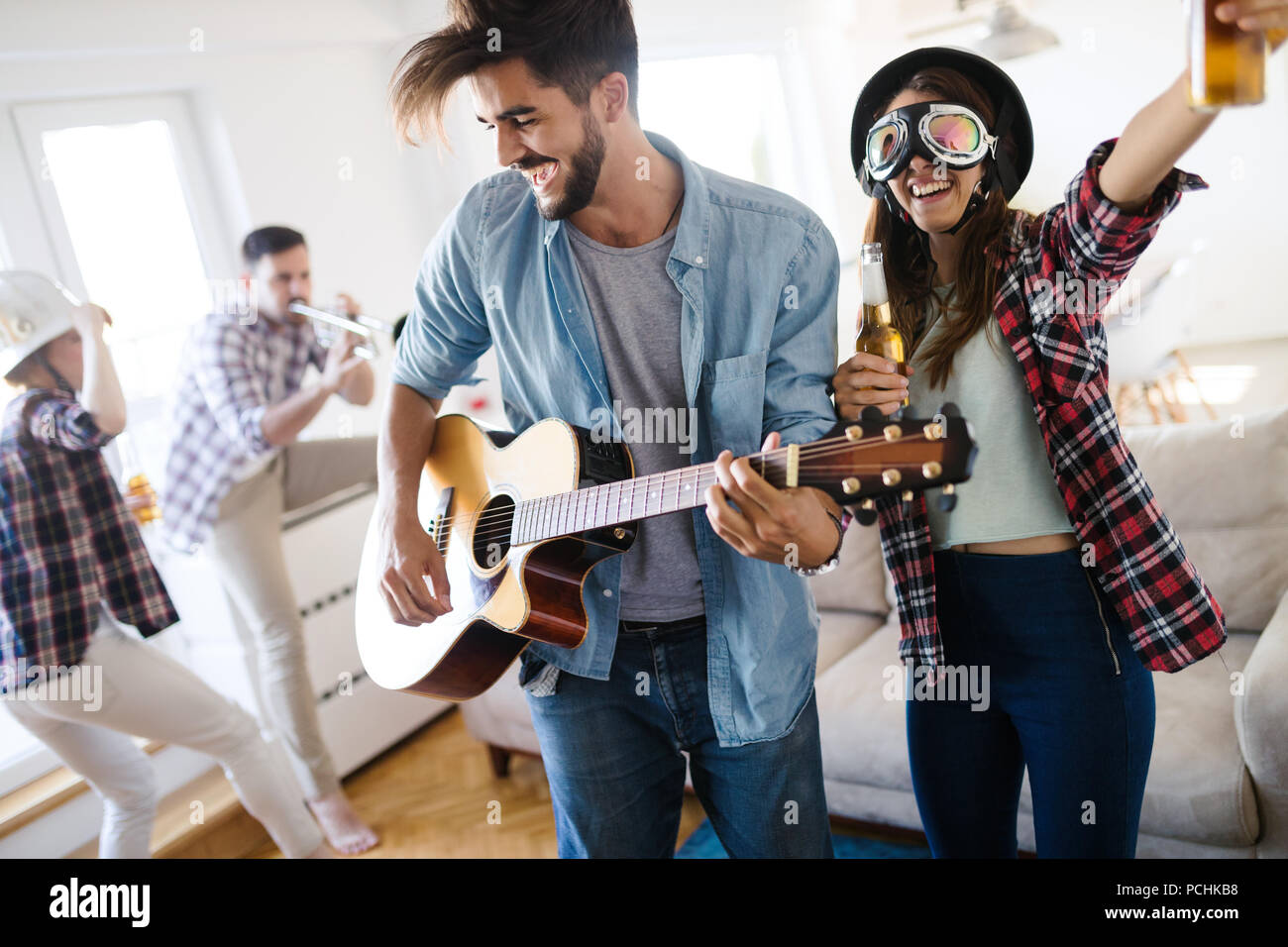 Cheerful friends having party together and playing instruments Stock ...