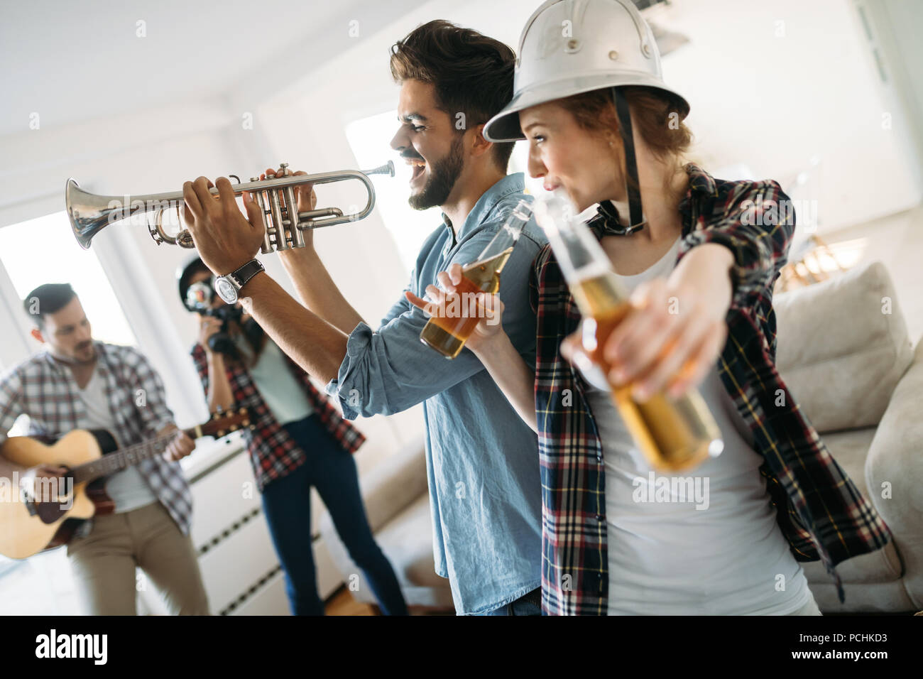 Cheerful friends having party together and playing instruments Stock ...