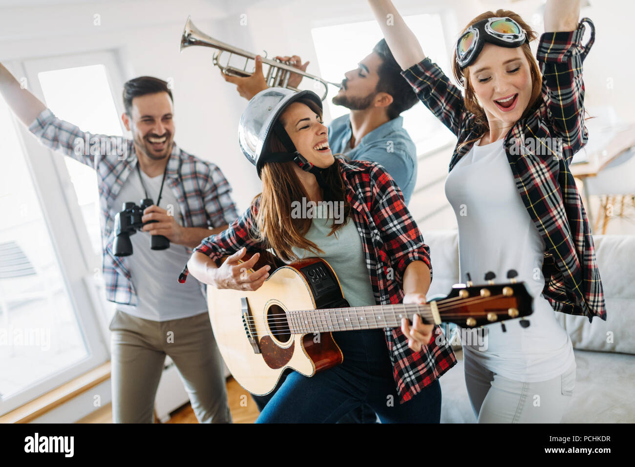 Cheerful friends having party together and playing instruments Stock ...