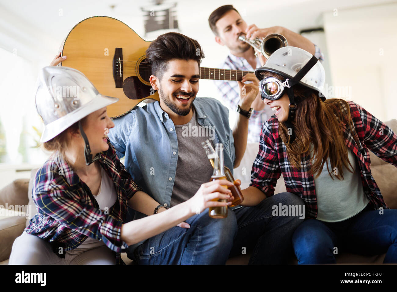 Cheerful friends having party together and playing instruments Stock ...