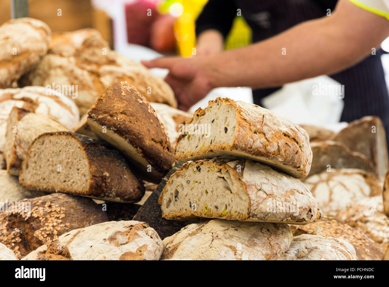 Freshly baked cut loafs of bread sold in the marketplace with hand ...