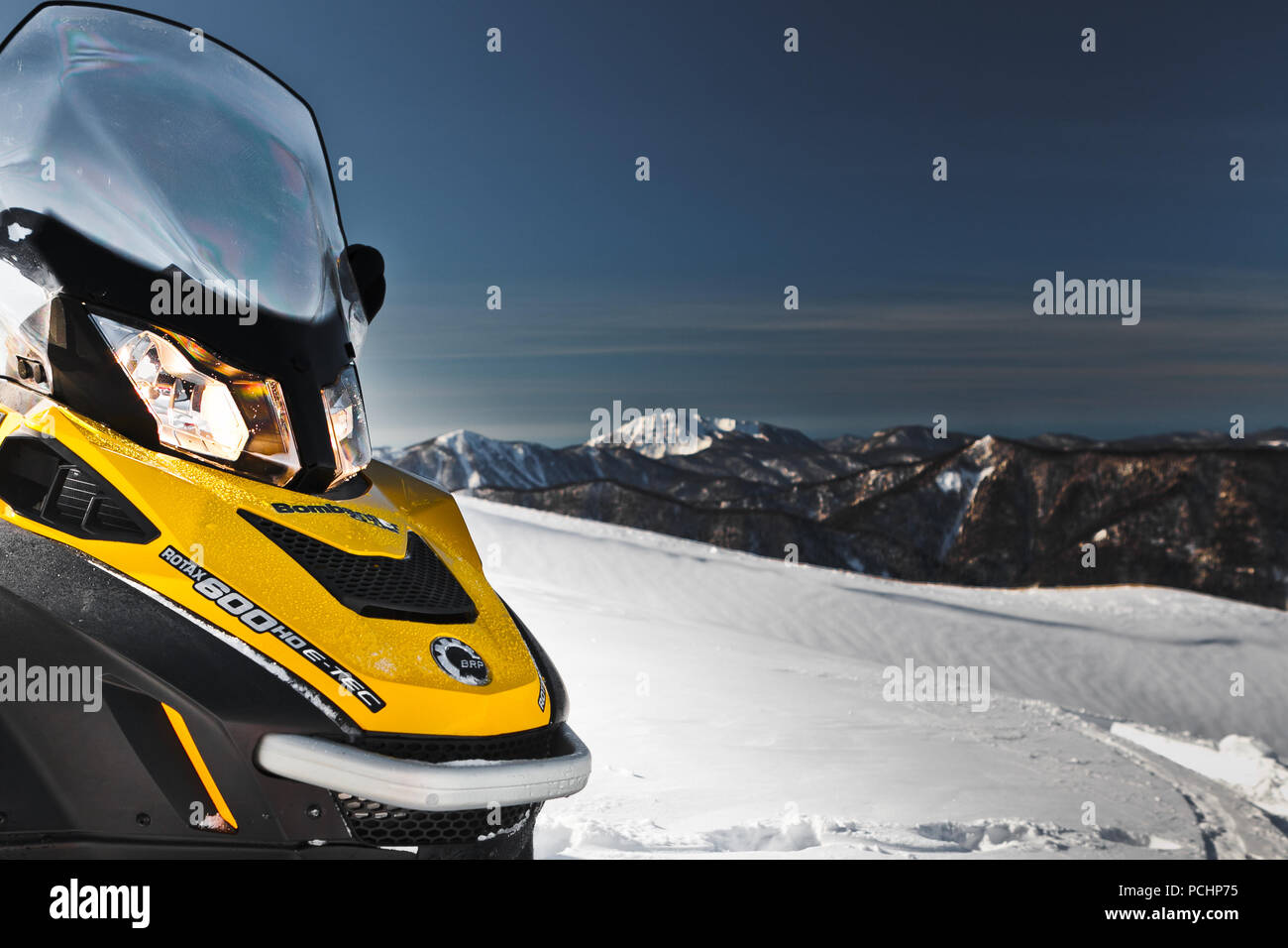 Snowmobile "BRP Skandiс" on the background of mountains on the plateau ...