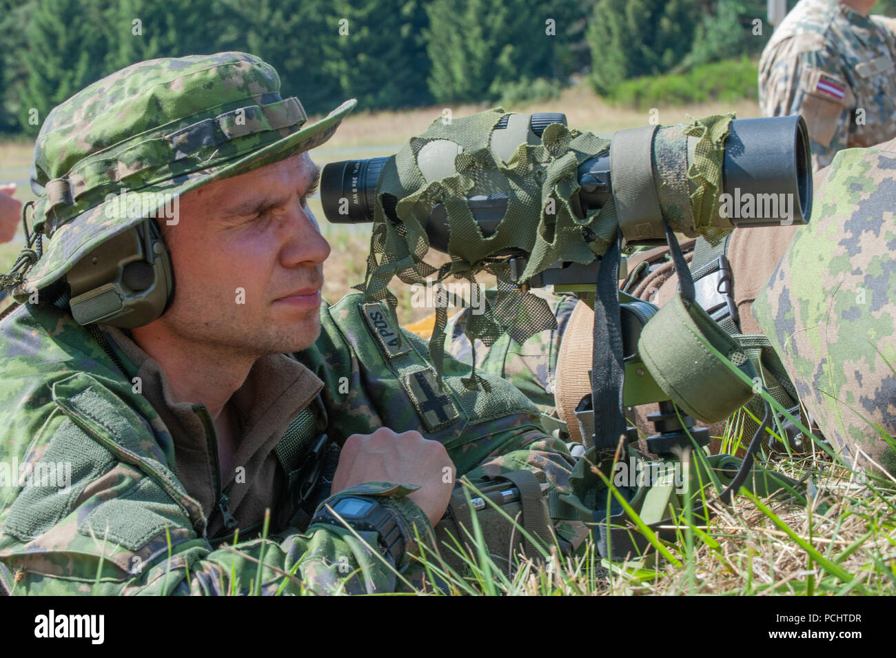 Sniper team spotter from Finland watches for the bullet trace of his ...